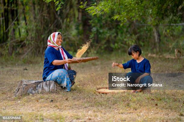Wanita Asia Senior Dengan Pakaian Tradisional Menampi Nasi Menggunakan ... Wanita Asia Senior Dengan Pakaian Tradisional Menampi Nasi Menggunakan ...