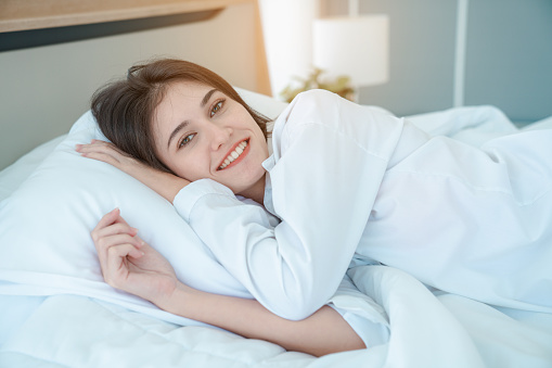 Photo Of Young Happy Woman In Pajama Stretching Her Arms And Smiling