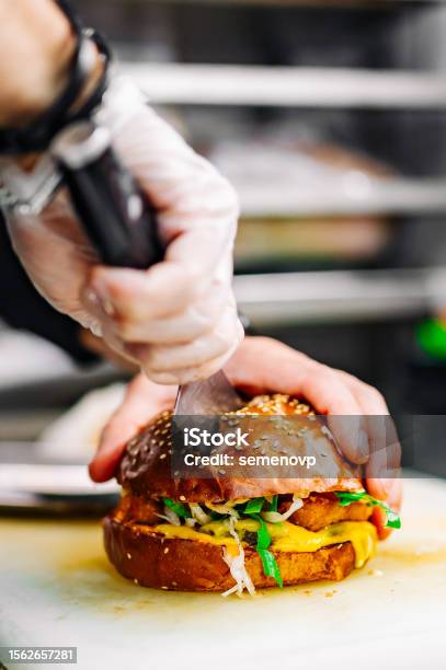 Burger Dengan Potongan Daging Sapi Tomat Keju Dan Selada Koki Di Dapur