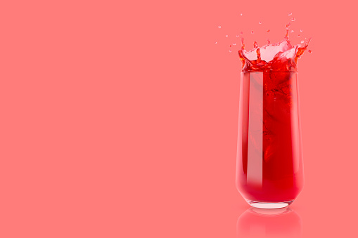 Jus Merah Segar Ceri Dalam Gelas Dengan Pantulan Tetes Dan Percikan Pada Latar Belakang Merah