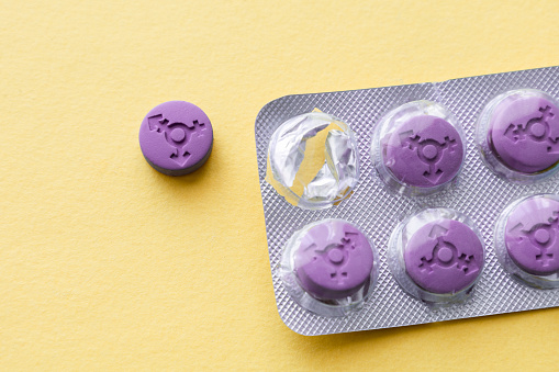 Purple Pill With A Transgender Gender Symbol In A Blister On A Yellow Background Hormonal Pills