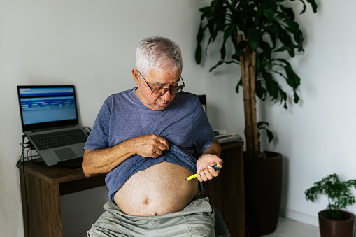 Elderly Man Takes A Break From Work At Home To Inject Insulin Stock ... Elderly Man Takes A Break From Work At Home To Inject Insulin Stock ...