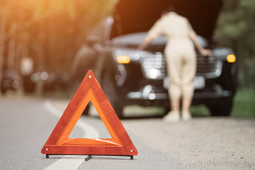 Warning Triangle Against Woman Driver Trying To Fix Defect In Engine ... Warning Triangle Against Woman Driver Trying To Fix Defect In Engine ...