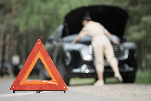 Warning Triangle Against Woman Driver Trying To Fix Defect In Engine ... Warning Triangle Against Woman Driver Trying To Fix Defect In Engine ...