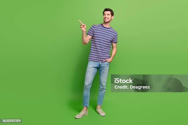 Full Length Photo Of Funky Thoughtful Guy Wear Striped Tshirt Pointing