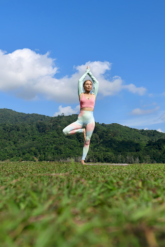 Mature Woman Practicing Yoga Outdoors Flowing Poses By A River Stock