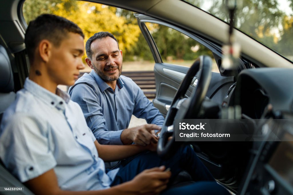 Father Instructing Son On Driving Introducing Him To The Car Stock