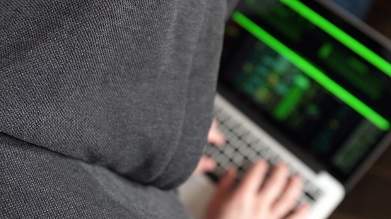 Anonymous Hooded Hacker Programming In Computer Console Breaking