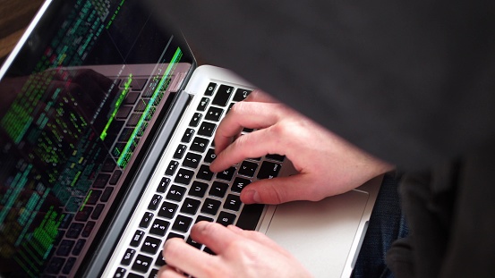 Anonymous Hooded Hacker Programming In Computer Console Breaking