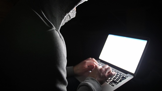 Anonymous Hooded Hacker Programming In Computer Console Breaking