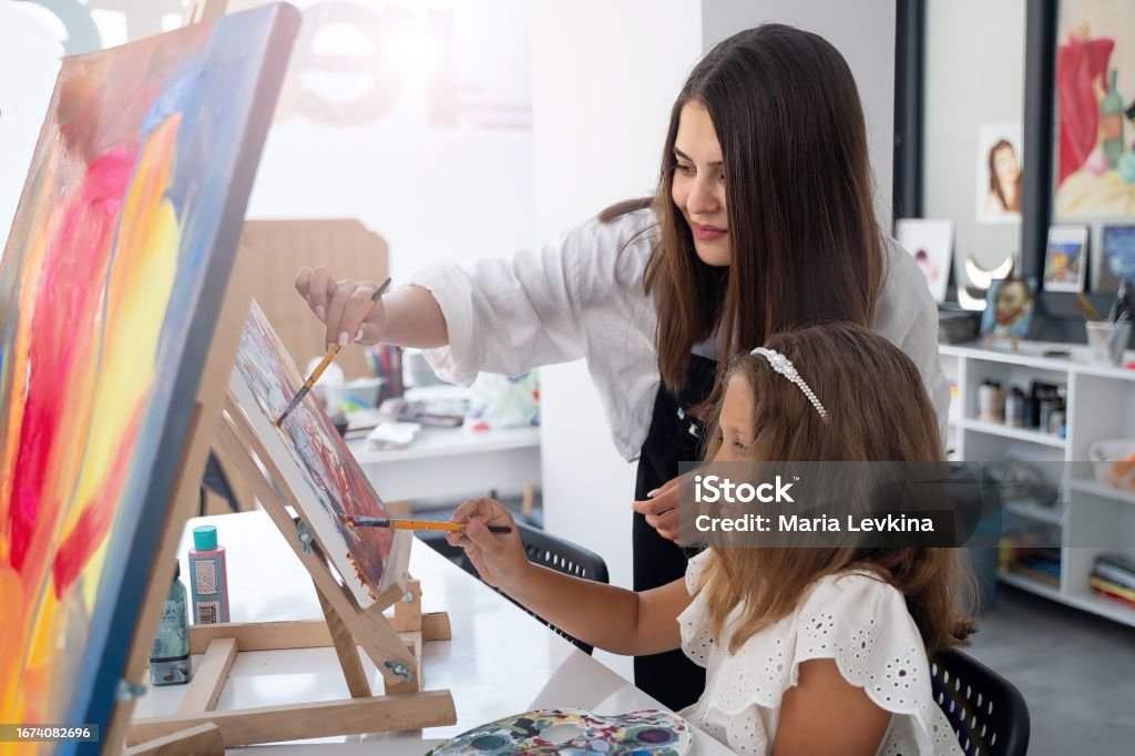 Guru Di Sekolah Seni Membantu Anakanak Di Kelas Seni Dengan Melukis ... Guru Di Sekolah Seni Membantu Anakanak Di Kelas Seni Dengan Melukis ...