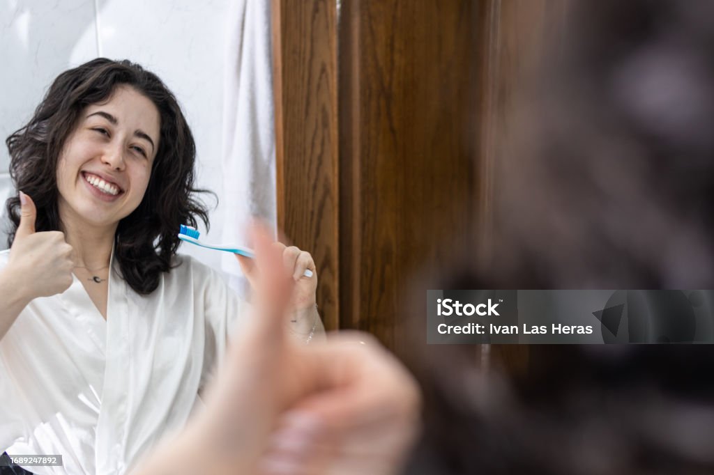 Happy Woman Brushing Her Teeth In The Bathroom Mirror Happy Girl