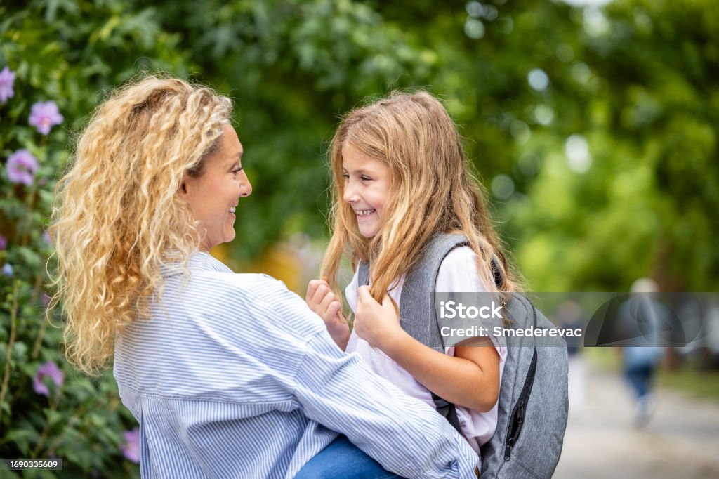 Mother And Daughter Embracing And Kissing Before Leaving To School Love