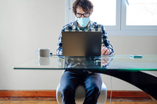 Free Stock Photo of A man wearing a mask and glasses sitting at a desk | Download Free Images ...