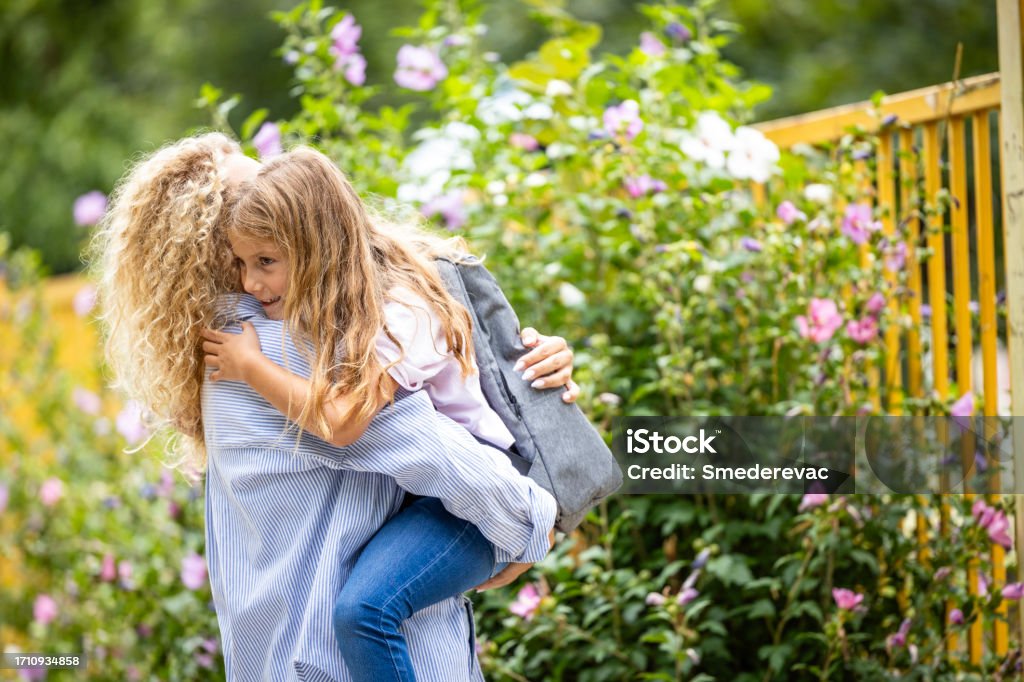 Mother And Daughter Embracing And Kissing Before Leaving To School
