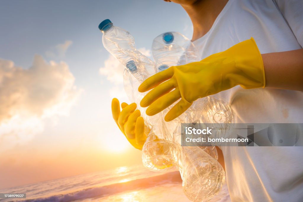 Relawan Remaja Lakilaki Memegang Sampah Botol Plastik Di Pantai Untuk