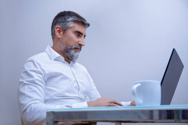 Free Stock Photo of Man Sitting at Table Using Laptop Computer ...