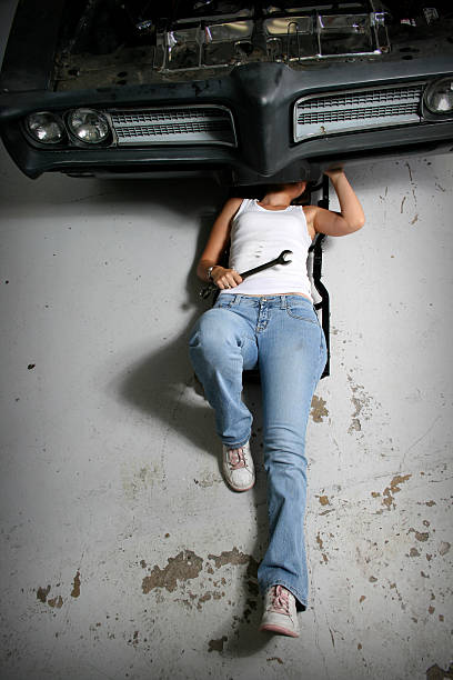 Free Stock Photo of Young female mechanic on a creeper under a car ...