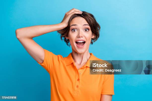 Photo Of Girly Shocked Girl Dressed Orange Polo Arm Head Open Mouth Isolated Blue Color