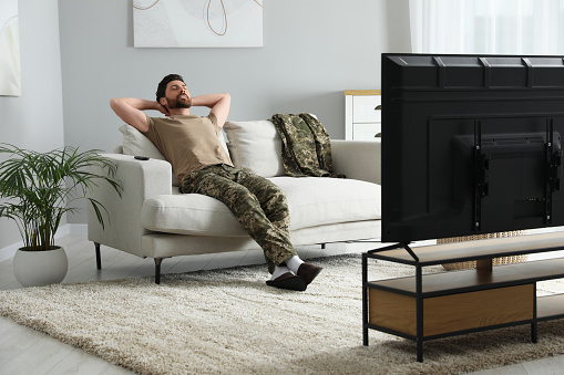 Soldier Napping On Soft Sofa Near Tv In Living Room Military Service
