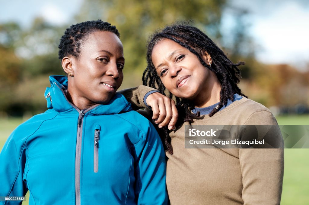 Two Mature Women Friends Posing Together In A Park In Autumn Stock