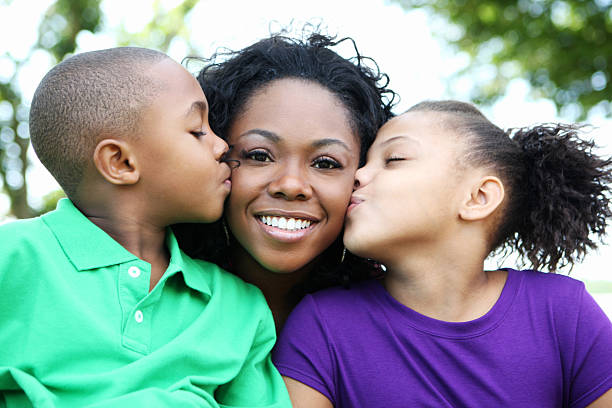 60 Son And Daughter Hugging Mother And Kissing On Her Cheeks Stock
