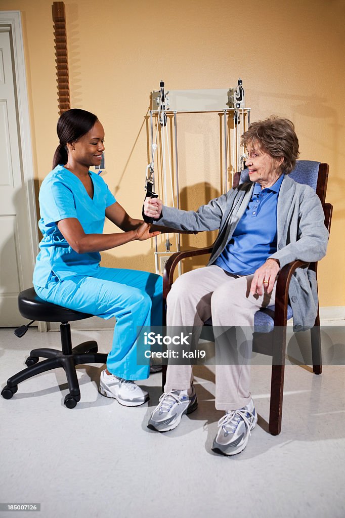 Physical Therapist Working With Patient On Upper Extremity Exerc Stock