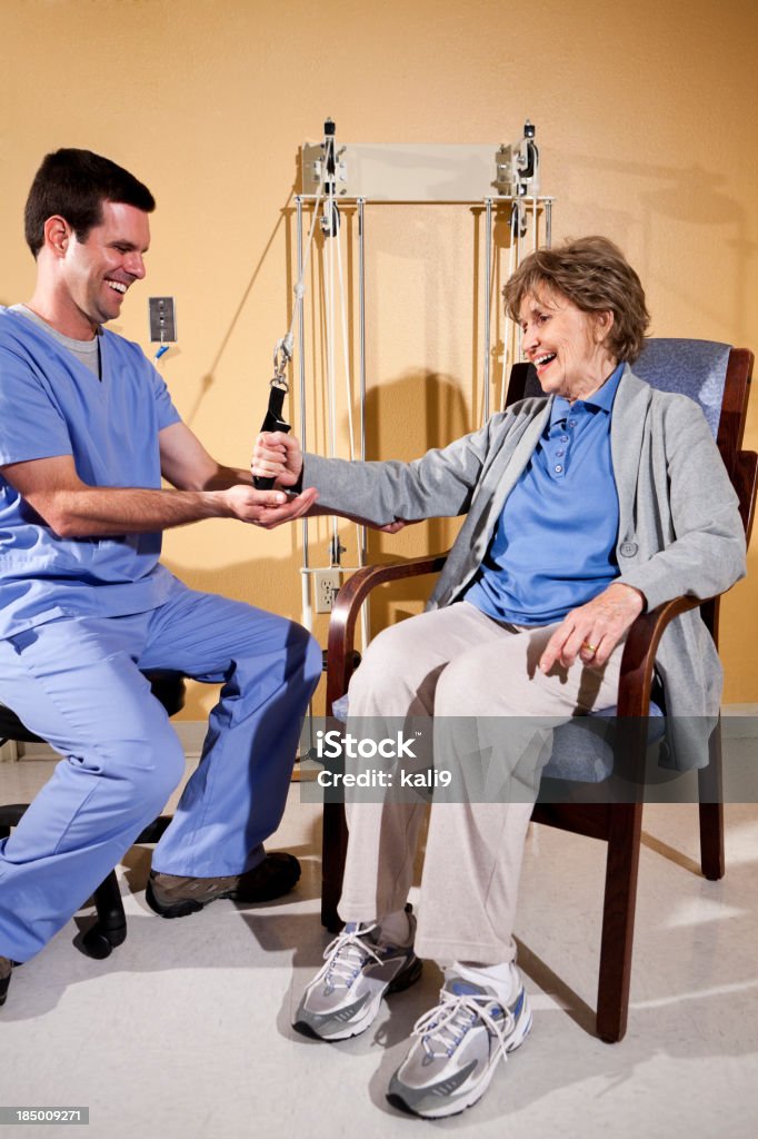 Physical Therapist Working With Patient On Upper Extremity Exerc Stock