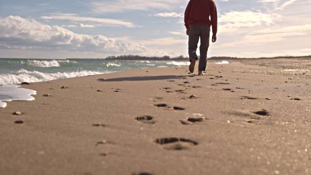 Free Stock Photo of Man Walking Along Sandy Beach Next to Ocean ...