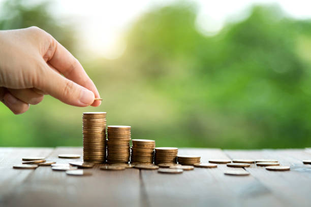 Free Stock Photo of Hand placing coins on a coin stack with upward ...