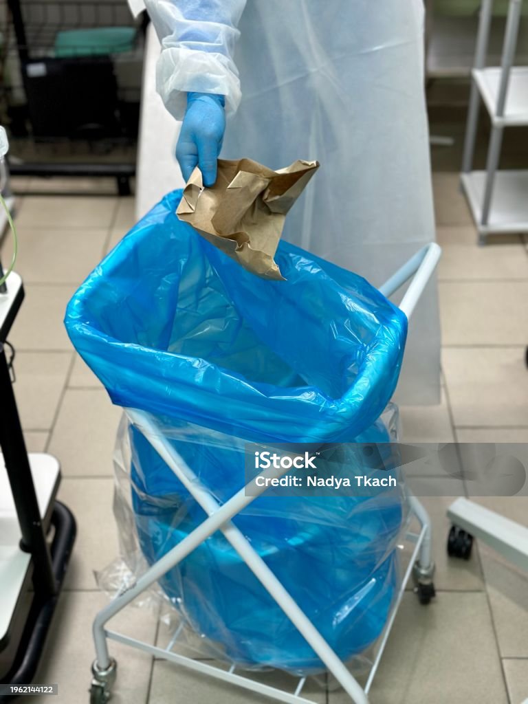 Close Up Of Hospital Worker Discarding Infectious Medical Waste Into ... Close Up Of Hospital Worker Discarding Infectious Medical Waste Into ...