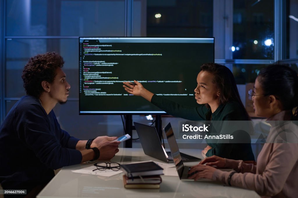 Young It Specialists Having Meeting In Evening Stock Photo - Download ... Young It Specialists Having Meeting In Evening Stock Photo - Download ...