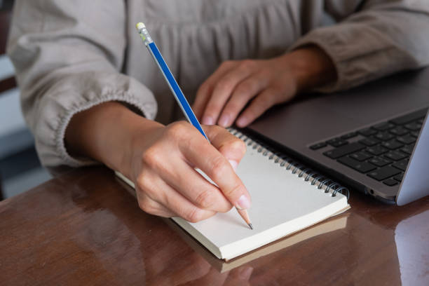 Free Stock Photo of Person Writing on Paper Next to Laptop | Download ...