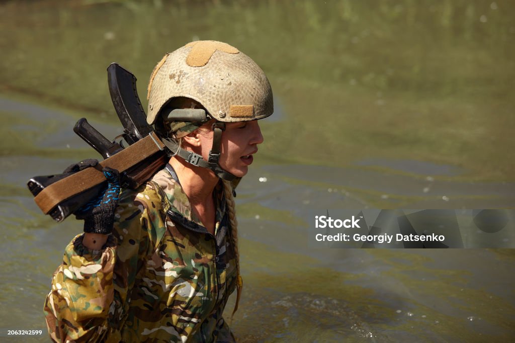 Portrait Of Fit Military Female Holding Weapon Rifle In Hands In River