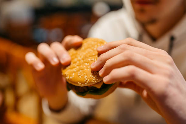 Free Stock Photo of Guy eating a burger, holding with both hands ...
