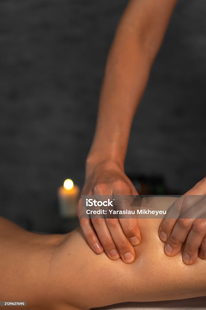 Closeup Massage Therapist Massages The Calf Muscle Of A Young Woman Spa
