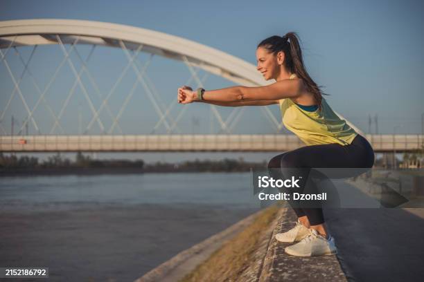 Sporty Woman Doing Warm Up Squat Stretching Near River 1人のストックフォトや画像を
