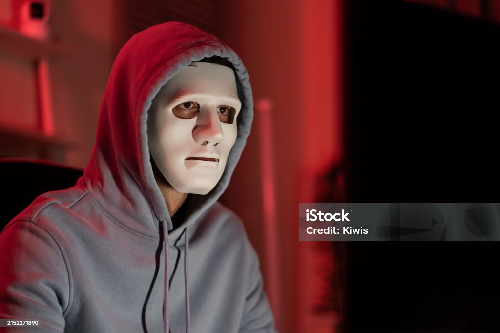 Short Of Computer Hacker Wearing White Mask Stealing Data From A Laptop