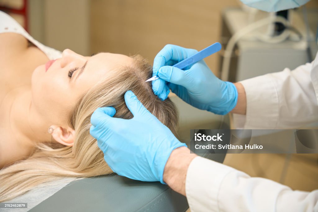 Dermatologist Performing Surgical Removal Of Sebaceous Cyst On Client