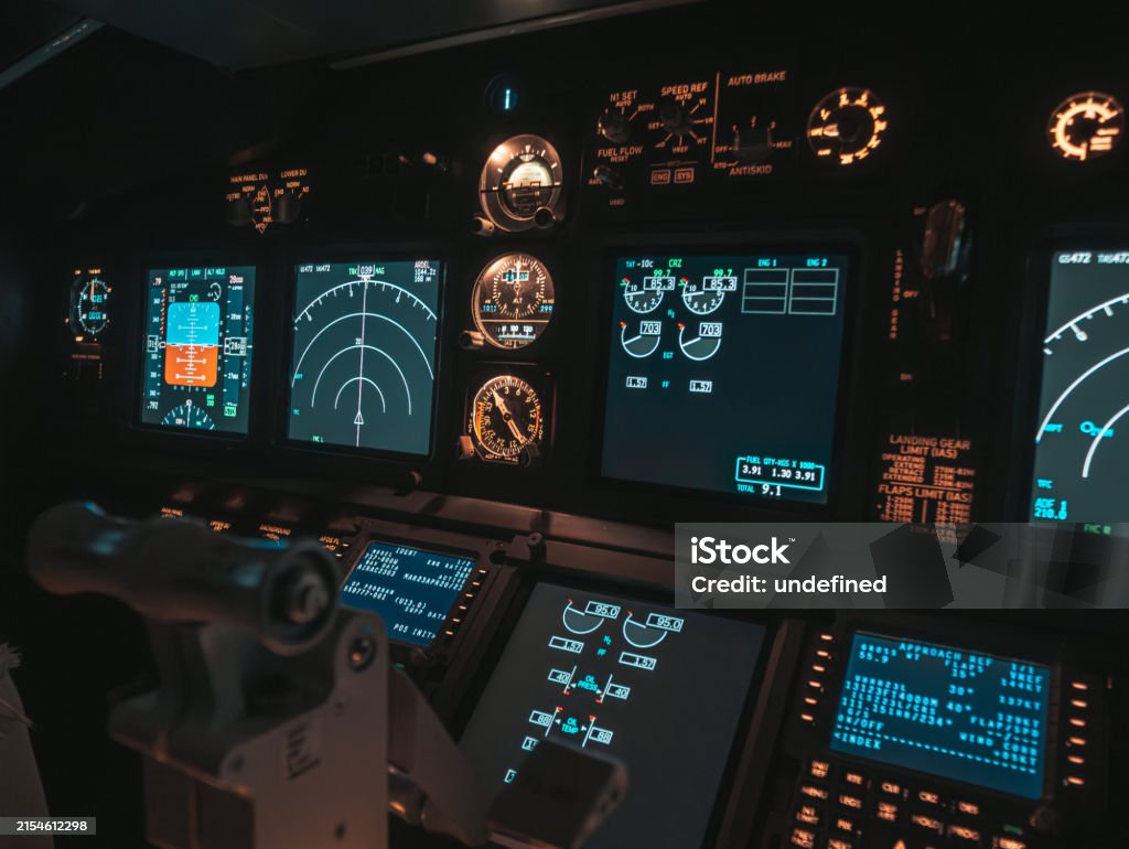 Cockpit View Of An Airplane During A Nighttime Flight With Illuminated Instrument Panels Stock
