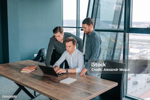 Three Young Businessmen Working Together In The Office Typing Away On ... Three Young Businessmen Working Together In The Office Typing Away On ...