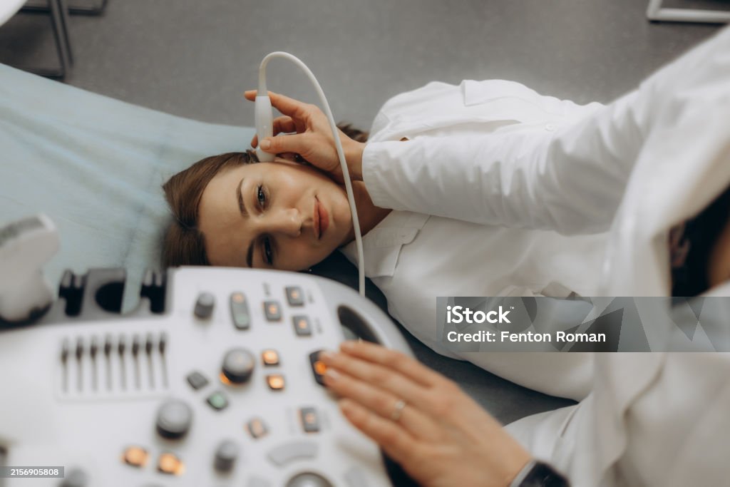 Doctor Using Ultrasound Scanning Machine For Examining A Head Of Woman
