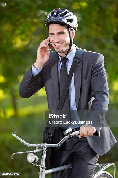 Young Businessman Wearing Bike Helmet And Using Mobile Phone Stock
