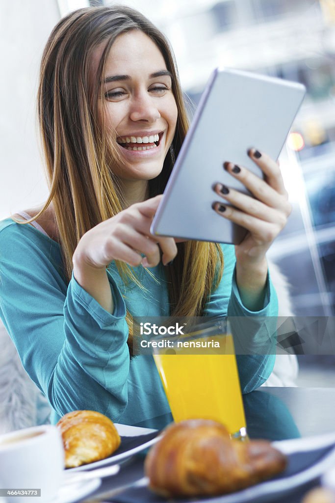 Pretty Woman Using Tablet While Having Breakfast In Coffee Shop Stock