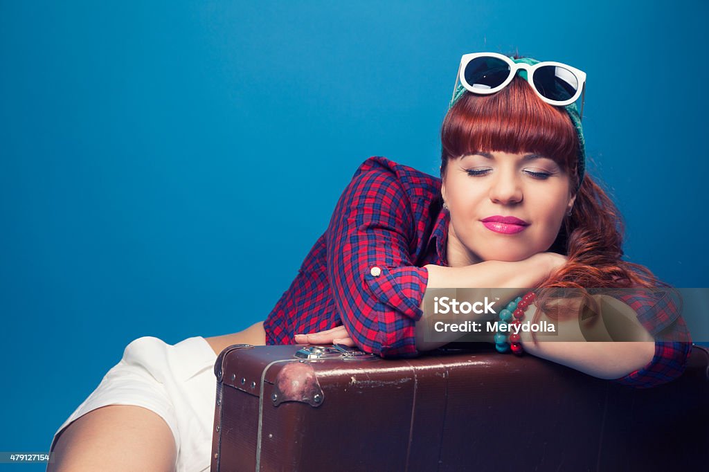 Beautiful Pinup Girl Posing With Vintage Suitcase Against Blue Stock