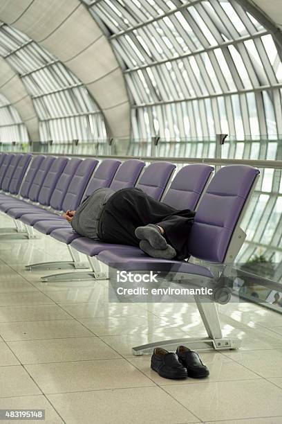 Tired Passenger Sleeping On Airport Chairs Waiting For Depature Stock