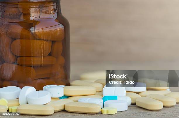 Banyak Pil Dan Vitamin Dalam Botol Obat Di Latar Belakang Kayu Foto