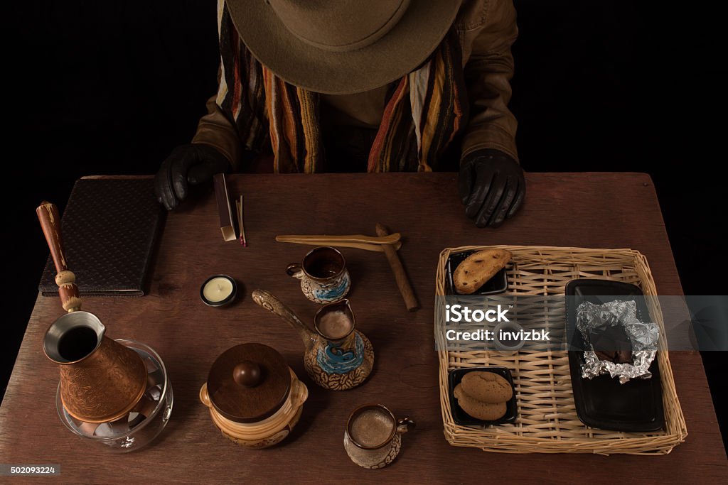 Orang Bertopi Dan Sarung Tangan Duduk Di Meja Kopi Foto Stok Unduh Gambar Sekarang Cerutu