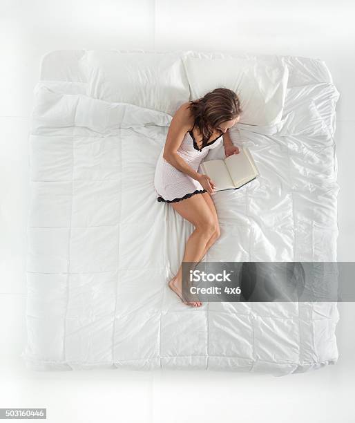 Di Atas Pandangan Perempuan Di Tempat Tidur Dan Buku Bacaan Foto Stok