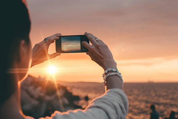 Free Stock Photo of A hand holding a phone taking a picture of a sunset ...